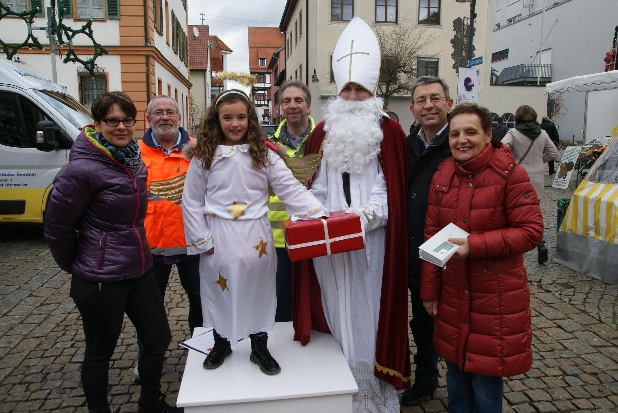 Engel Leyla zieht auf Wochenmarkt 15 Gewinnlose für Weihnachtsbäume